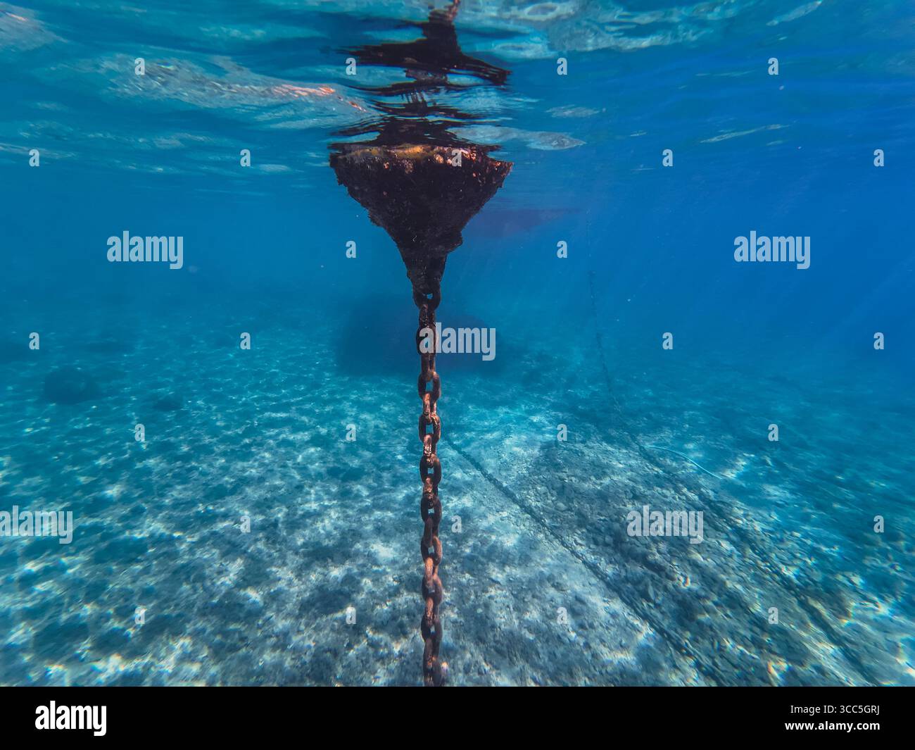 An atmospheric underwater view of a rusty mooring buoy chain in the ...
