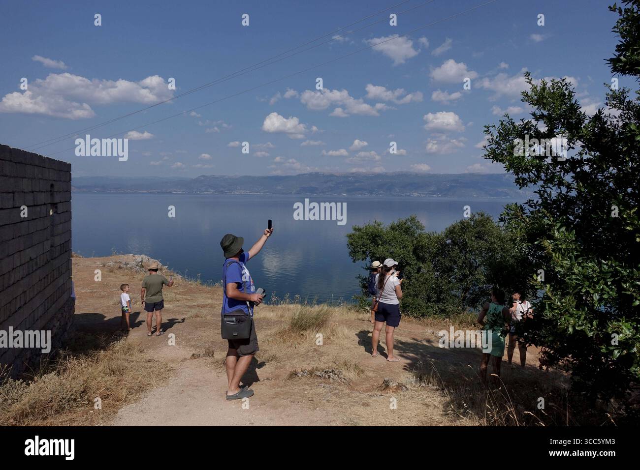 Tourists take pictures of Ohrid Lake near a IV-V century Paleochristian ...