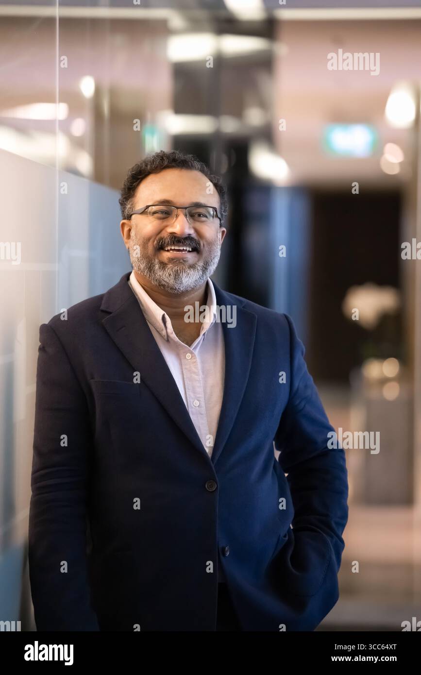 Positive older Indian company boss man standing in office hall Stock ...