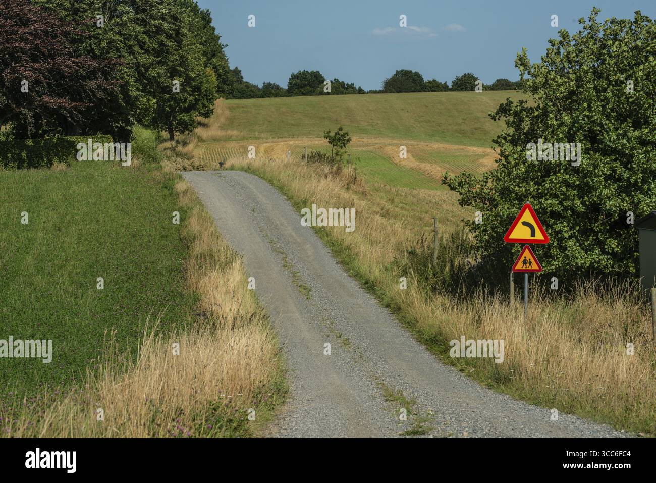 Curvy small gravel road with road sign in Ystad municipality, Skane ...