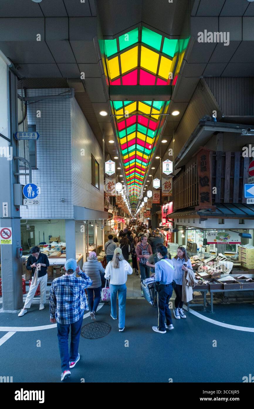 A vibrant market scene featuring shoppers exploring stalls under a ...