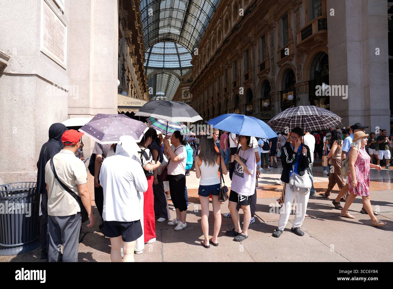 Milan, many tourists protecting themselves as best they can, with hats ...