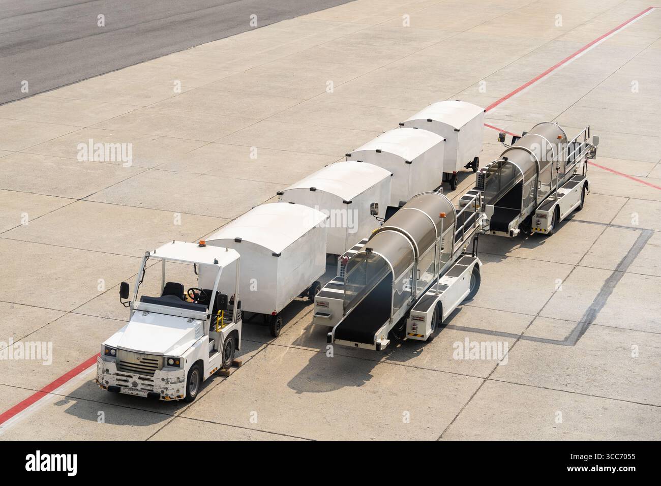 This is an airport baggage and cargo tractor pulling a train of luggage ...