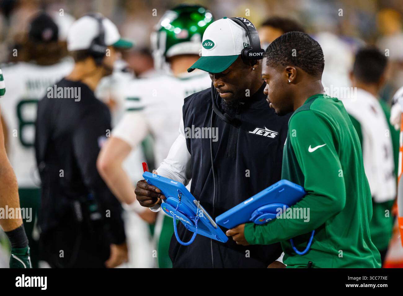 New York Jets' personnel look at a Microsoft Copilot tablet on the ...