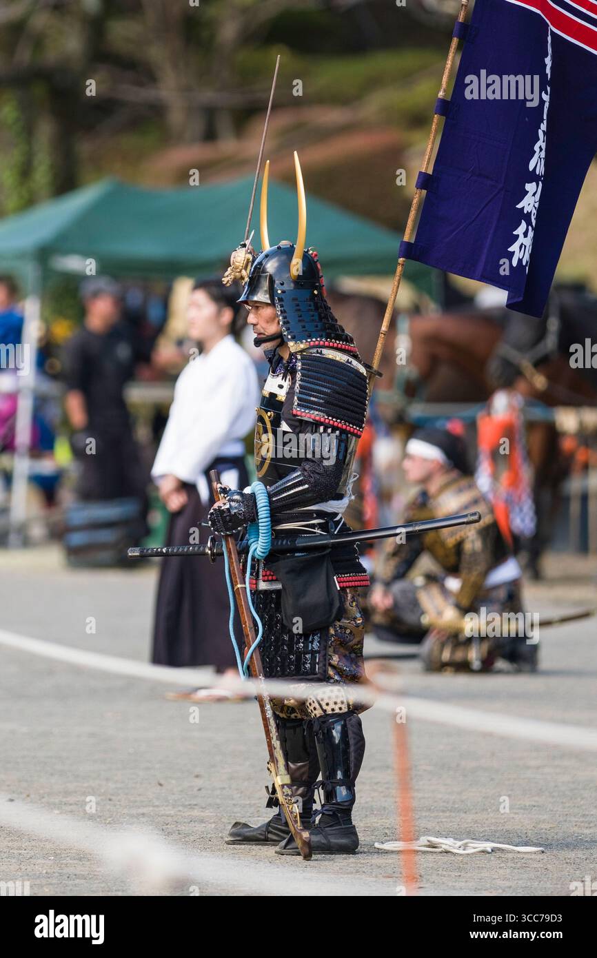A samurai dressed in traditional armor giving gunnery demonstration ...