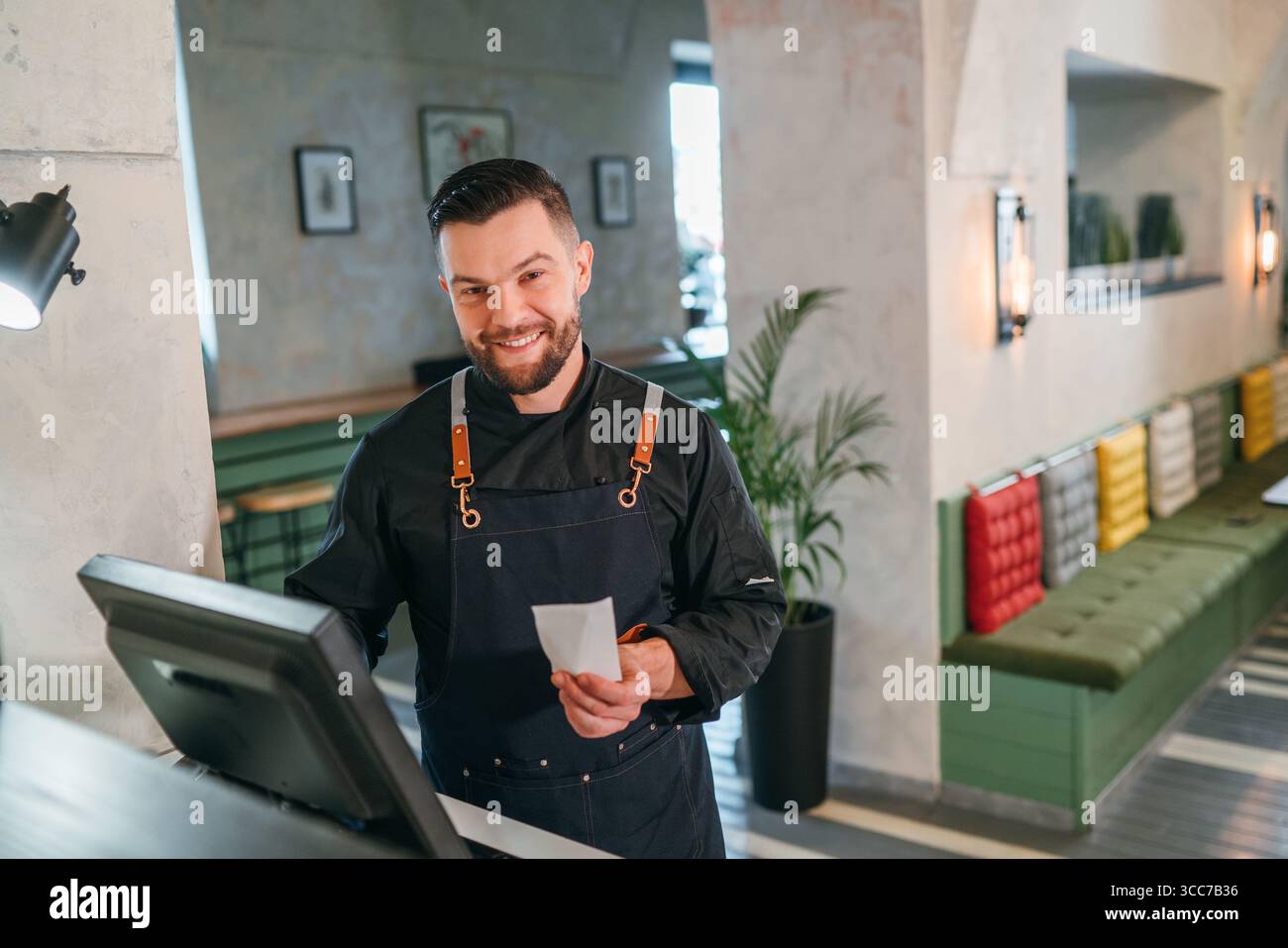 Stylish bearded smiling waiter dressed black uniform processing ...