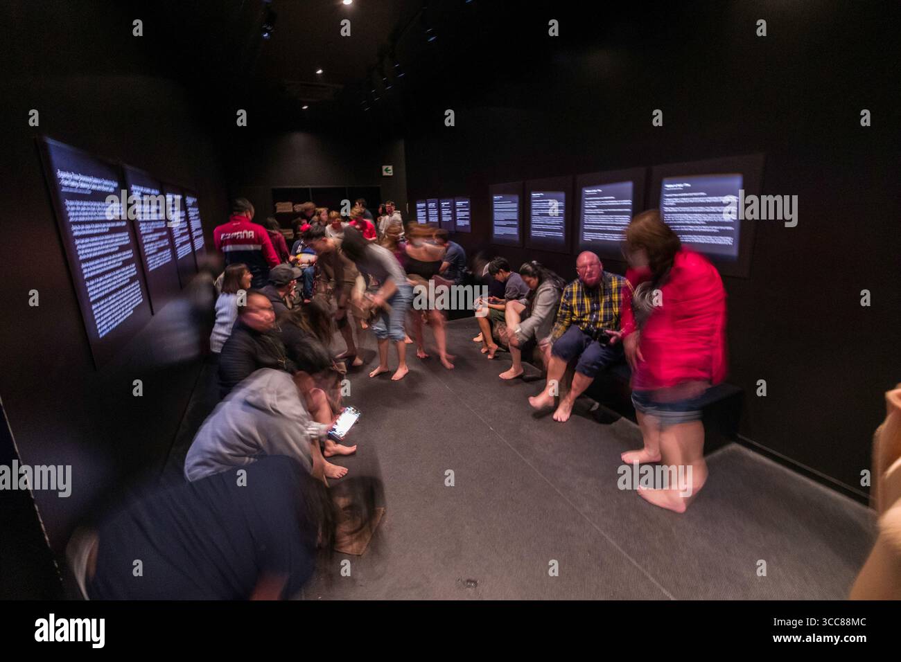 Visitors sitting drying their feet after walking in ankle deep water in ...