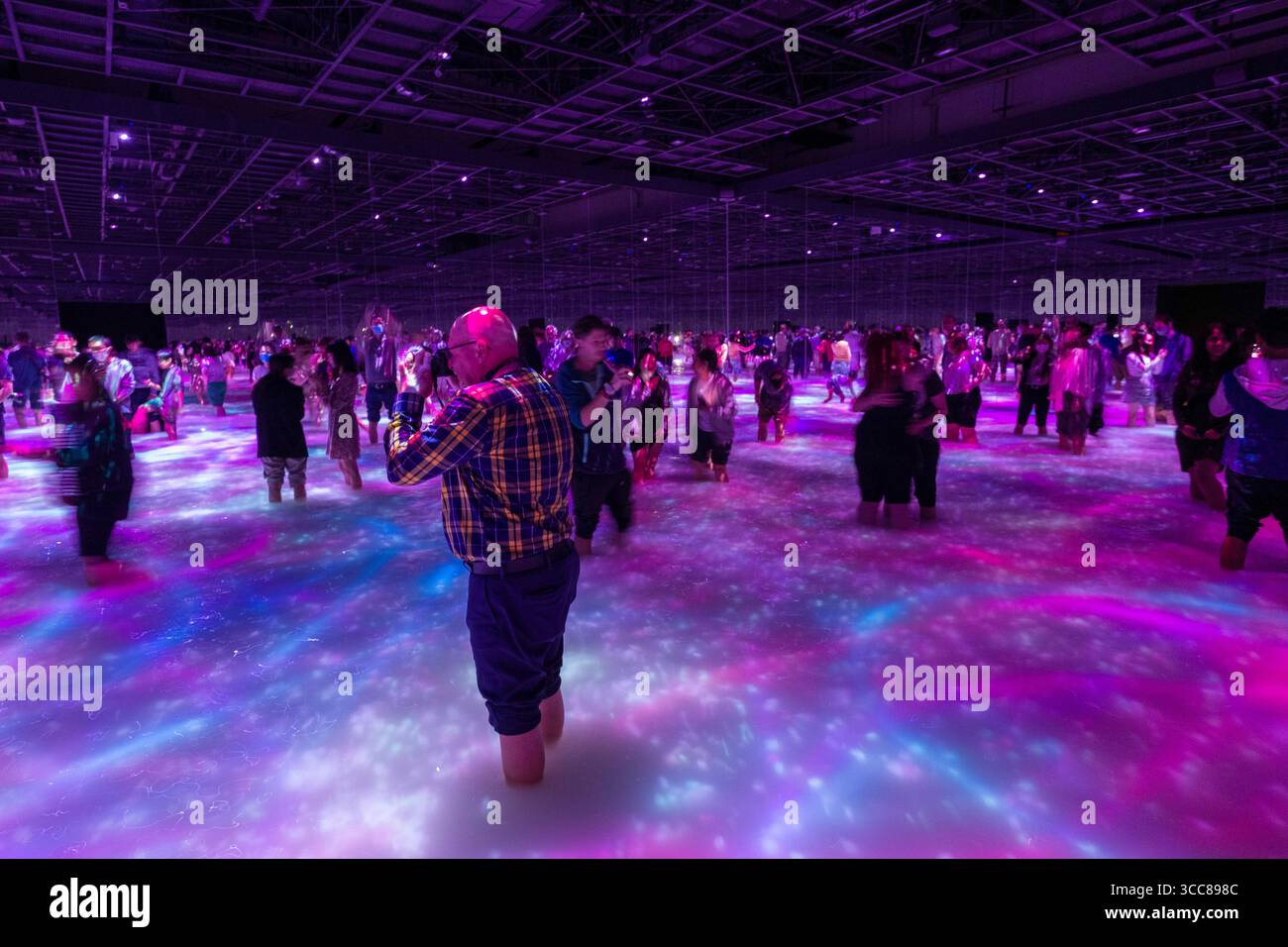 Visitors walking in ankle deep water enjoying the Dance of Koi and ...