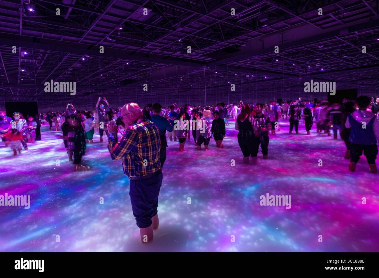 Visitors walking in ankle deep water enjoying the Dance of Koi and ...