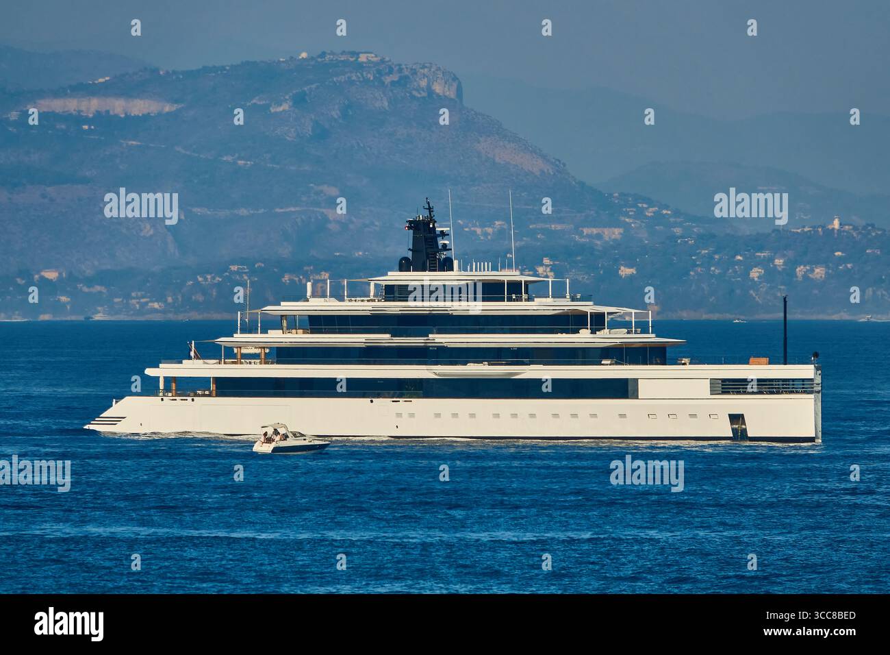Luxury Superyacht Ulyssess At Anchor with Scenic Coastline and Distant ...