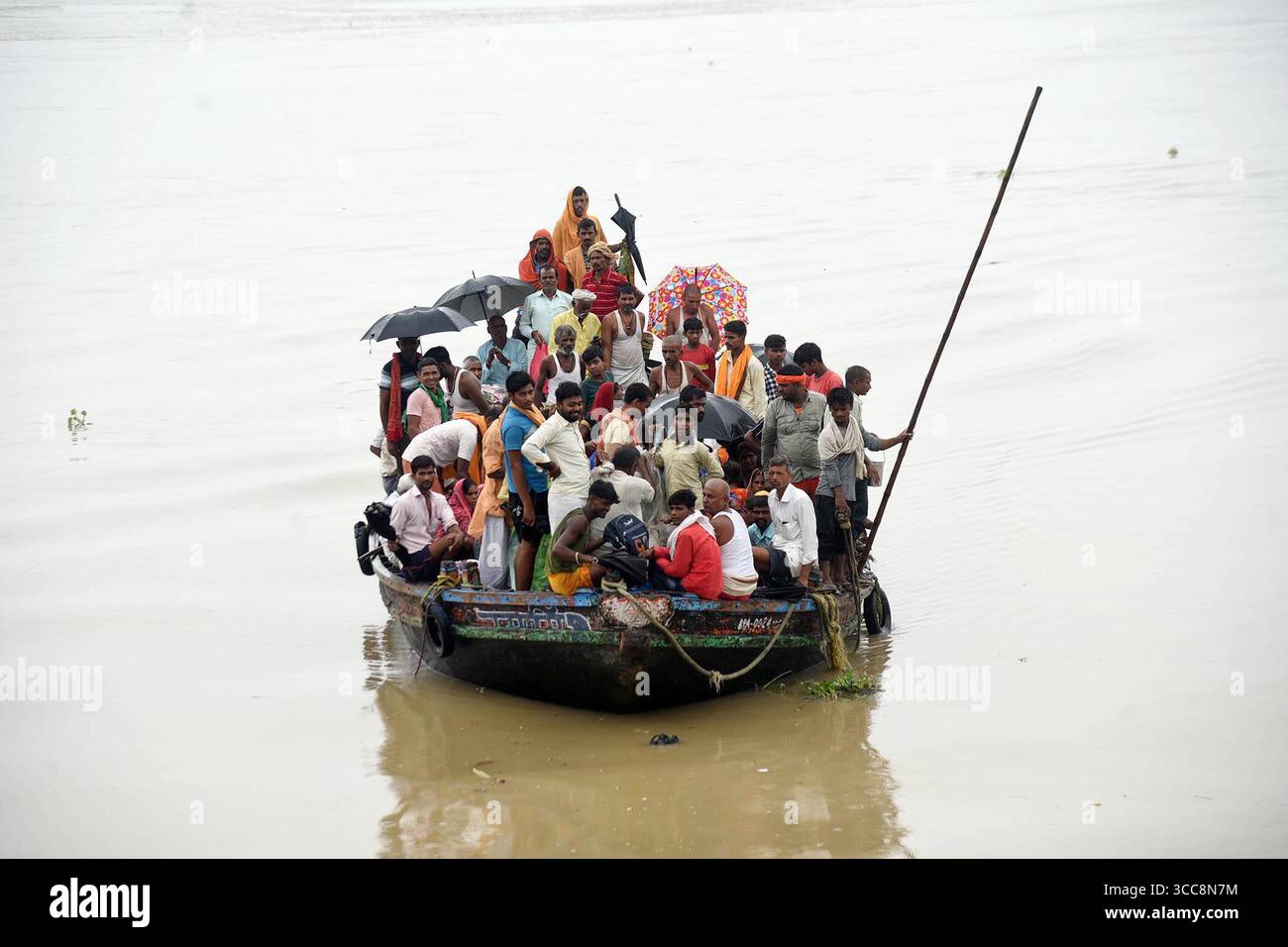 PATNA, INDIA - AUGUST 9: Flood victims wade through the water of the ...