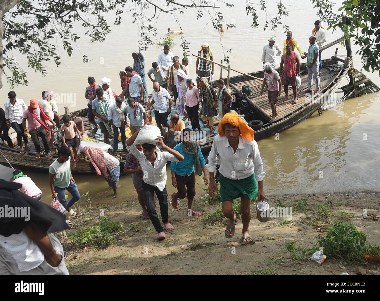 PATNA, INDIA - AUGUST 10: Flood victims wade through the water of the ...