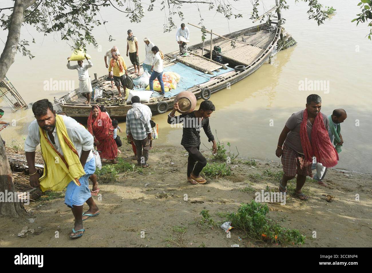PATNA, INDIA - AUGUST 10: Flood victims wade through the water of the ...