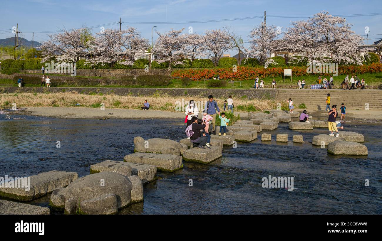 Adults and children testing their courage by crossing the Takano River ...