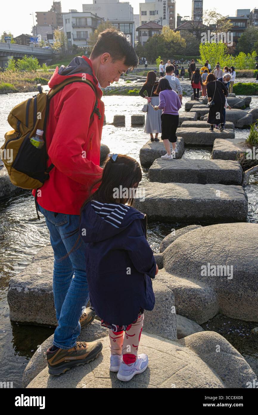 Adults and children testing their courage by crossing the Takano River ...