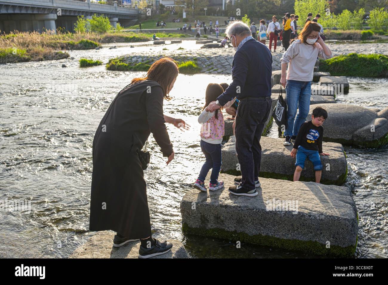 Adults and children testing their courage by crossing the Takano River ...