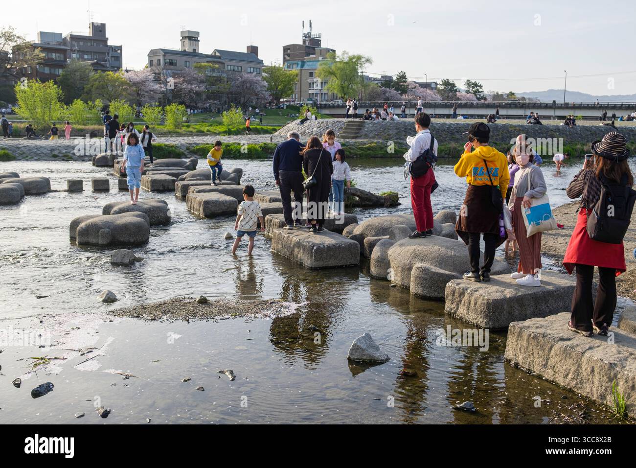 Adults and children testing their courage by crossing the Takano River ...