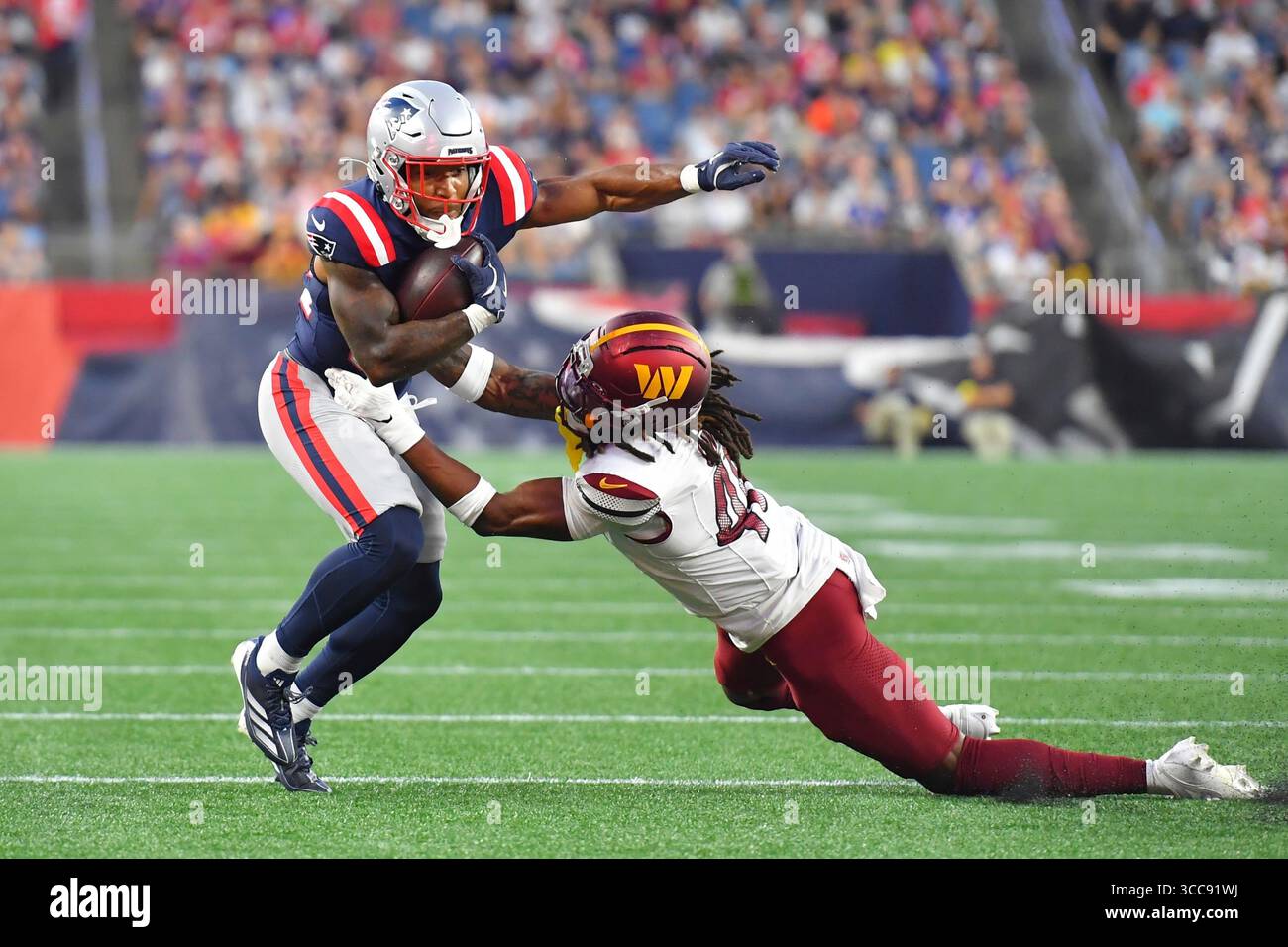 New England Patriots running back TreVeyon Henderson, left, eludes ...