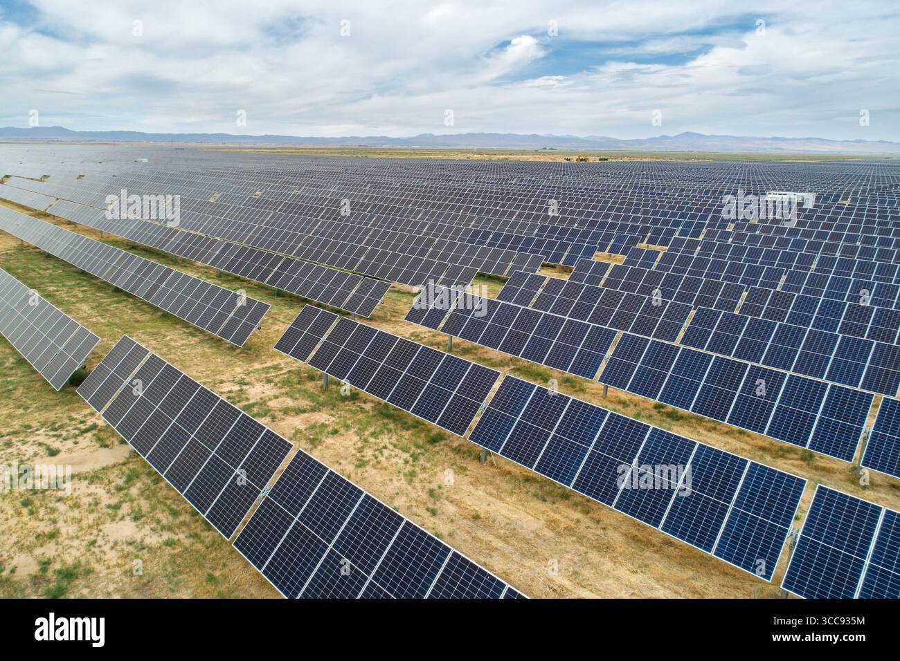 A large field of solar panels is shown in the image. The panels are ...