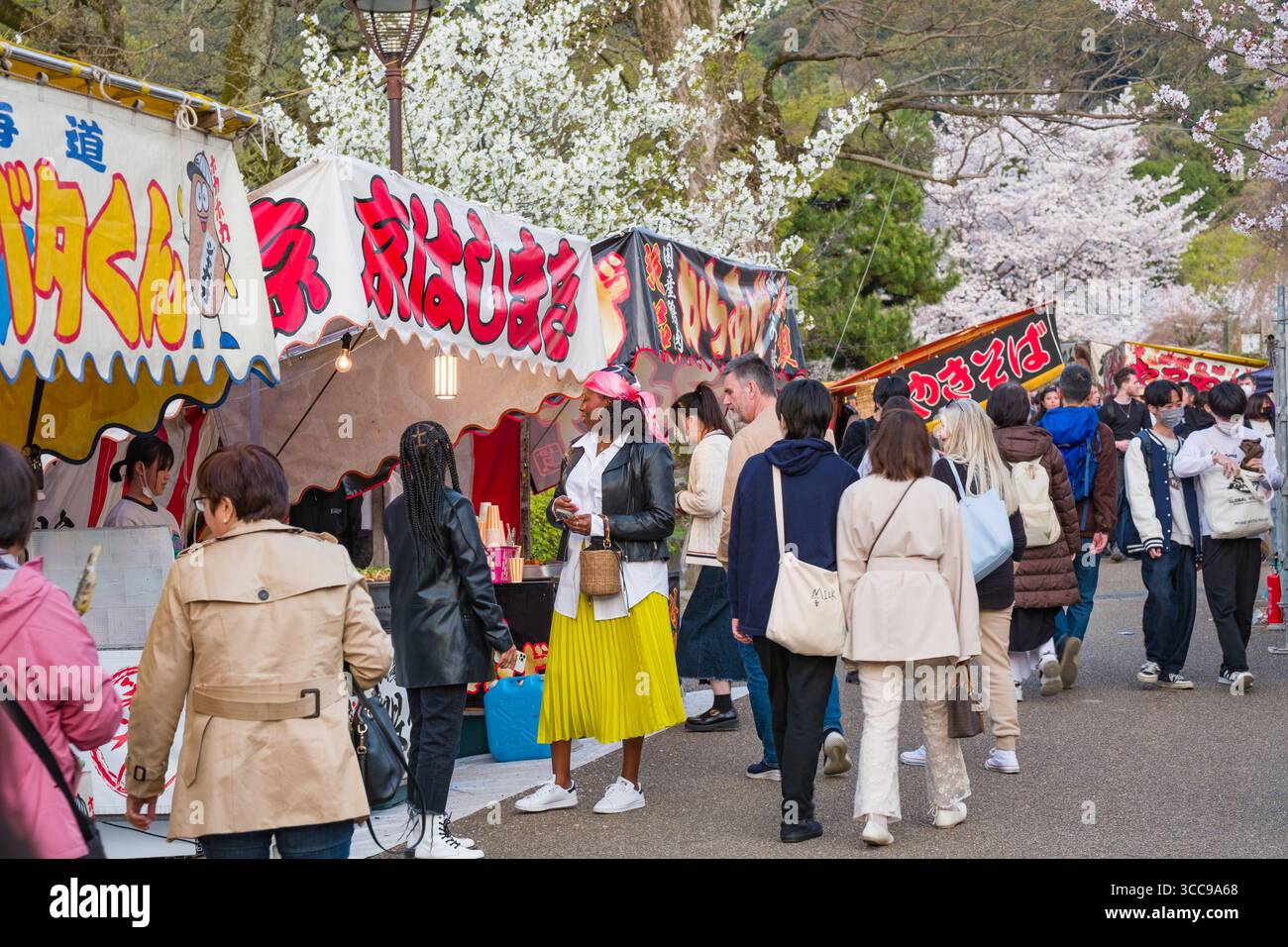 Vendors selling food from colorful temporary shelters during Hanami ...