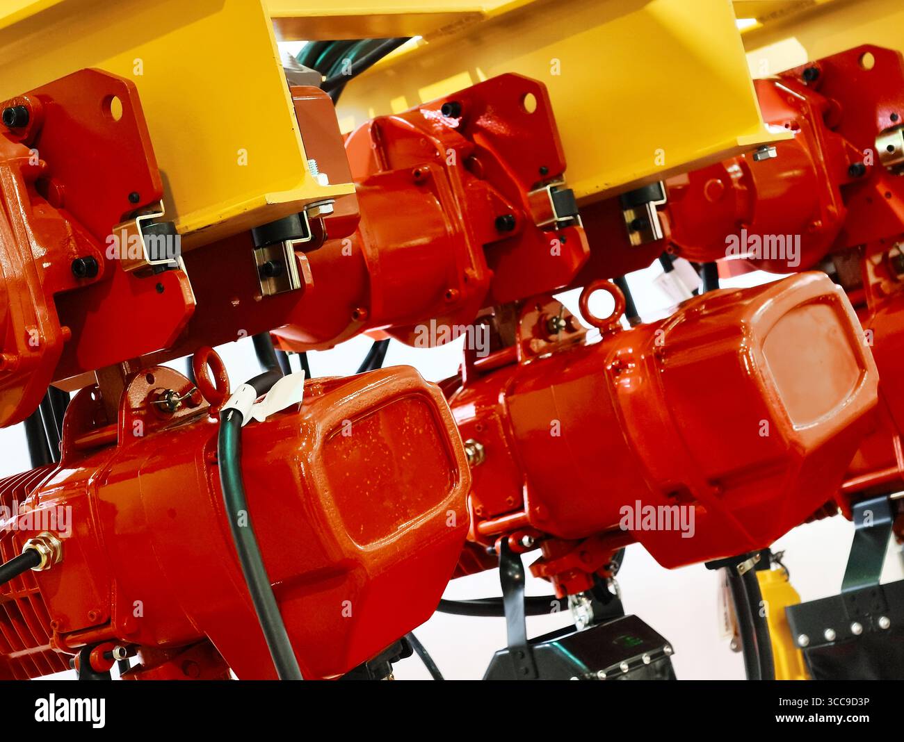 Red wire rope hoist machinery ready for lifting operations in a modern ...