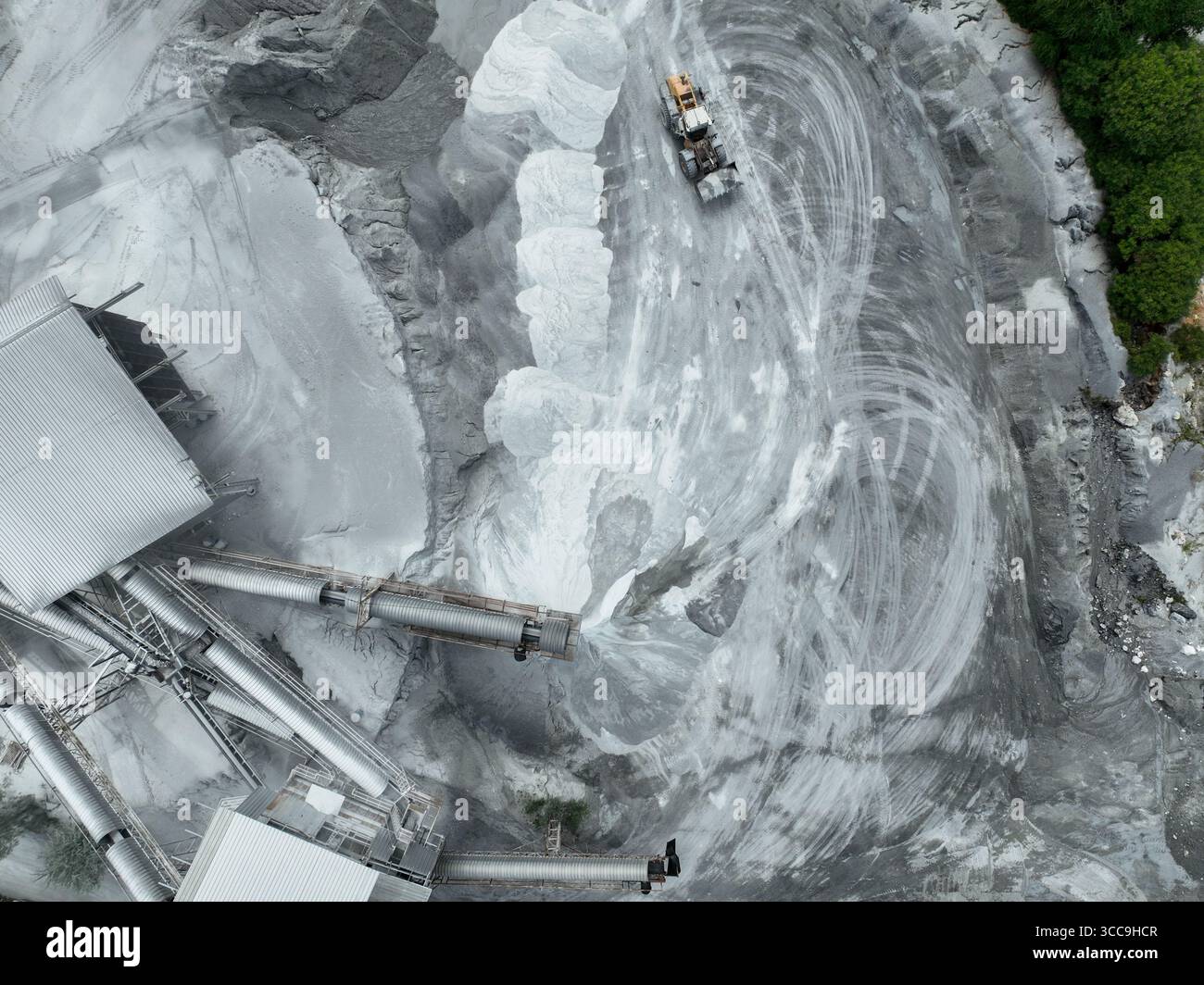 Top-down drone image of crushing plant and dust-covered trucks ...