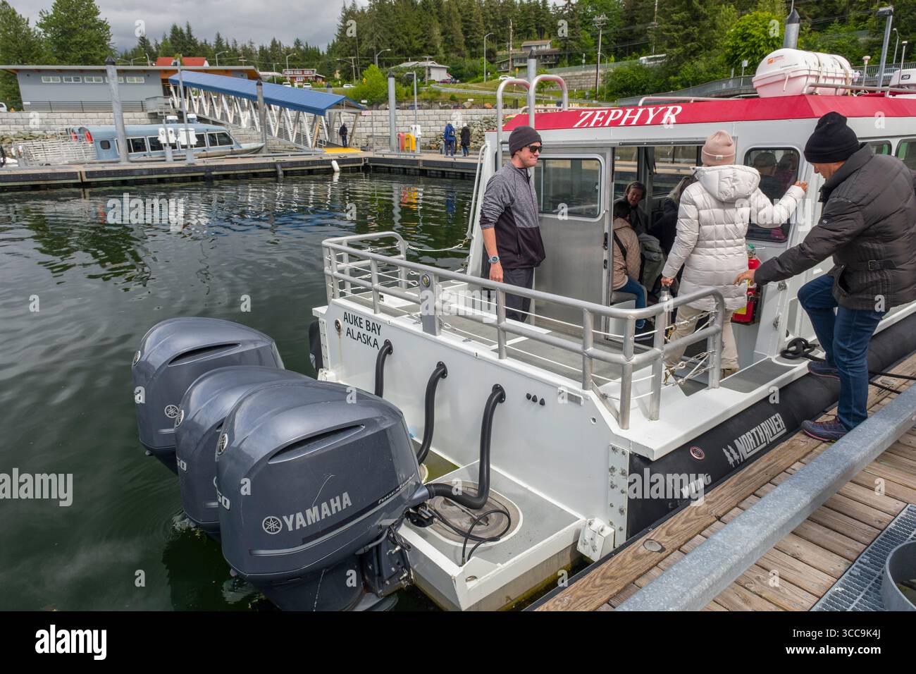 Tourist boarding Zephyr tour boat for a whale watching tour, Auke Bay ...