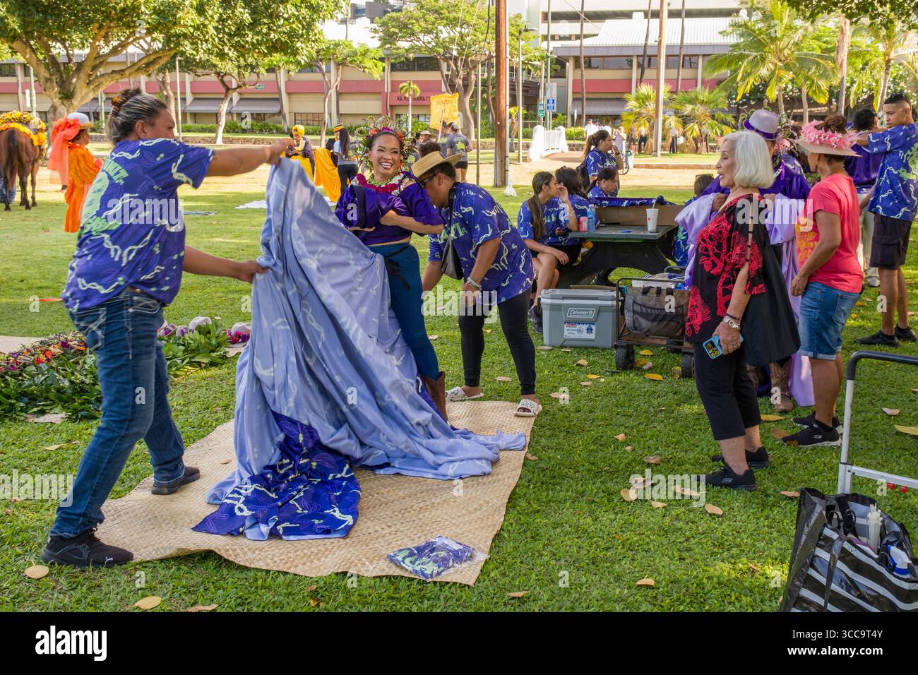 Two women helping to dress a female Pa’u rider before the start of the ...