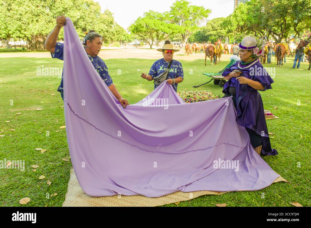 Two women helping to dress a female Pa’u rider before the start of the ...