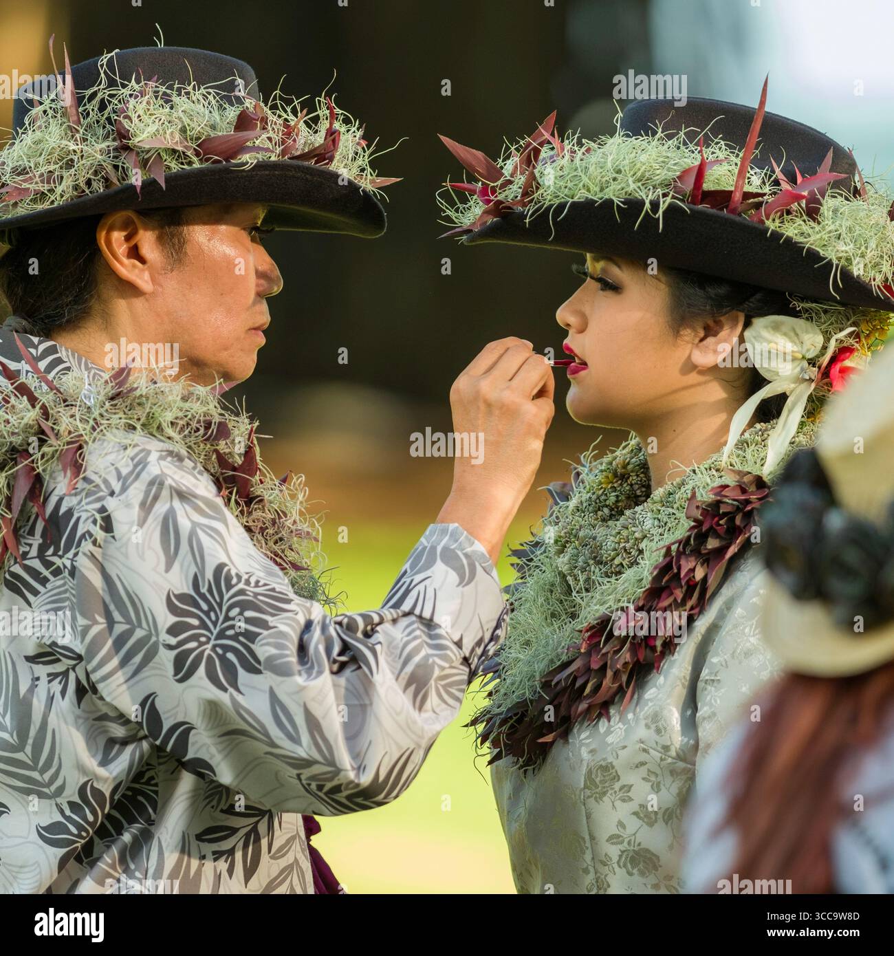 Male Pa’u rider applying lipstick to the lips of a female Pa’u rider before the start of the ...