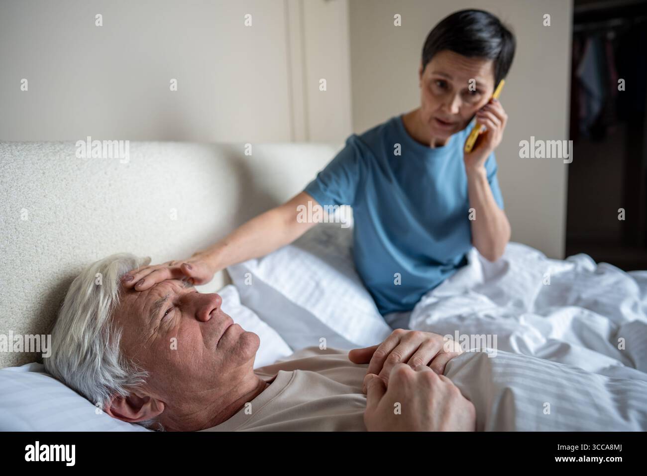 Exhausted feverish man with high temperature woman calling emergency ...