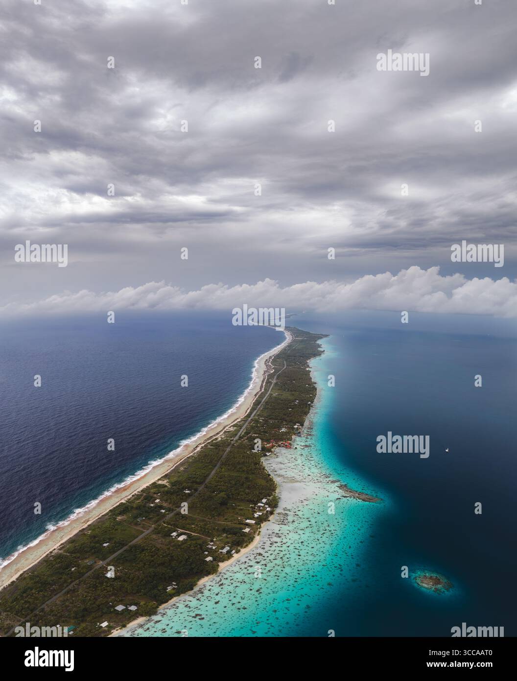 Aerial view of a thin strip of land separating the deep blue ocean from ...