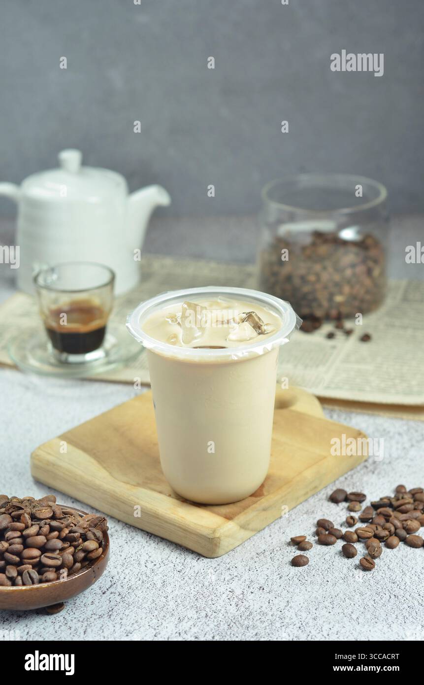 Ice coffee in a plastic cup with brown sugar and ice cubes and beans ...