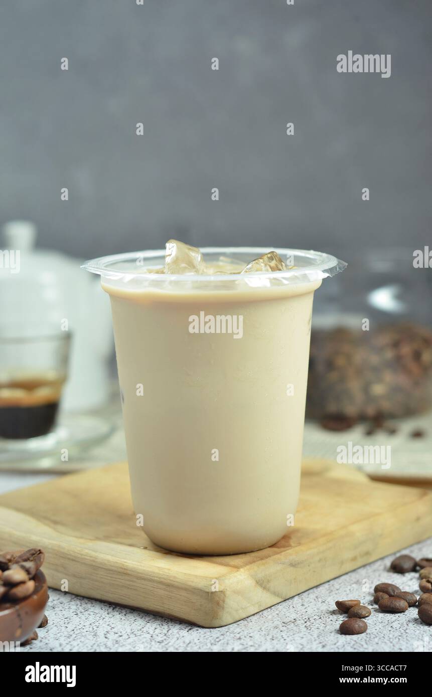 Ice coffee in a plastic cup with brown sugar and ice cubes and beans ...