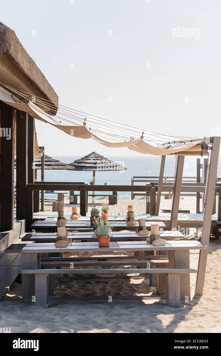 Beachfront restaurant tables under canopy with ocean view Stock Photo ...