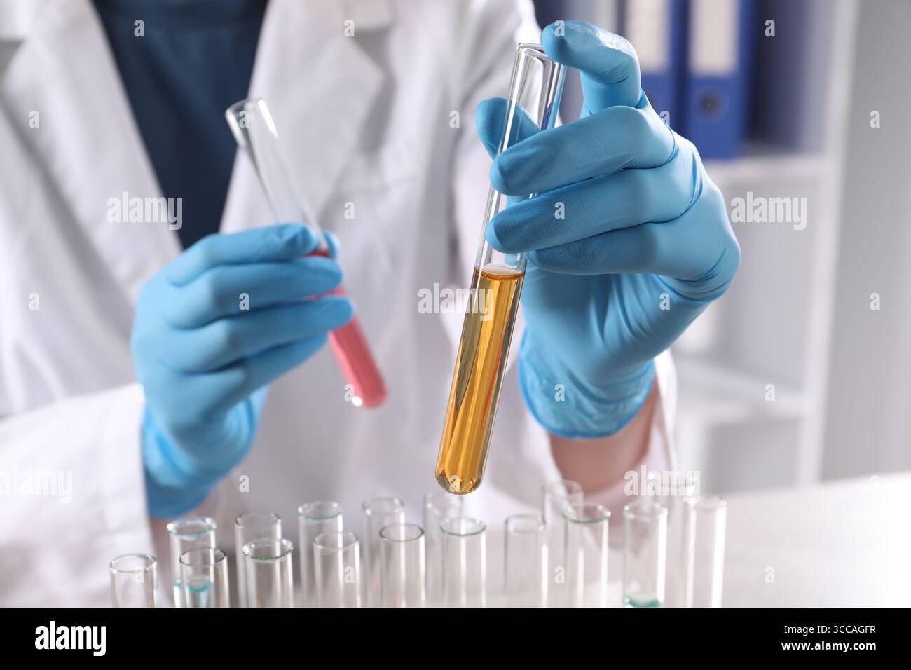 Scientist with test tubes of different samples in laboratory, closeup ...