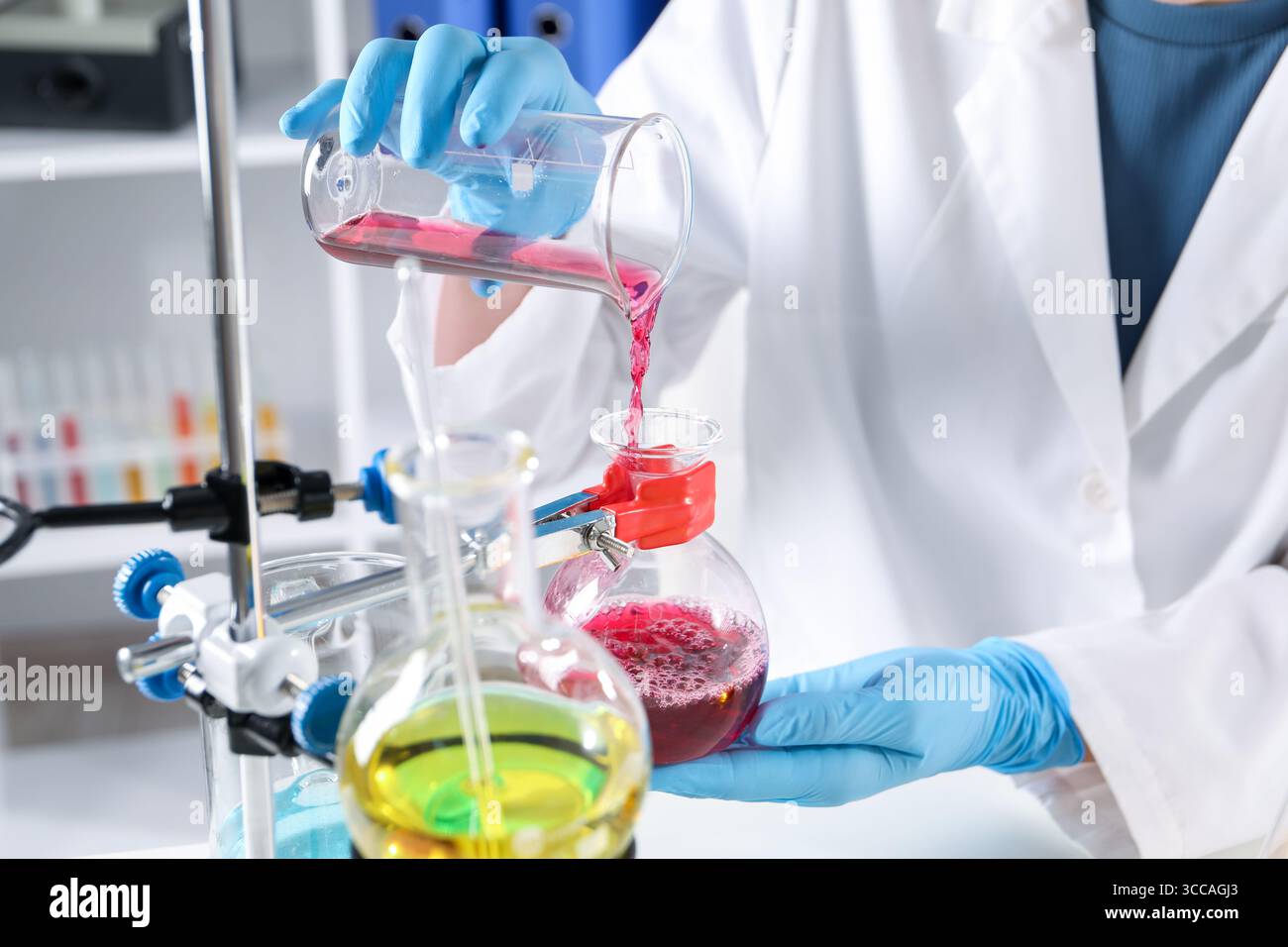 Scientist pouring sample in glass flask indoors, closeup. Solution ...