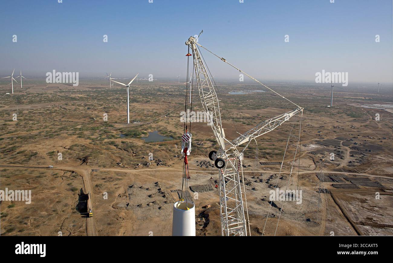 Aerial view of a stark landscape dotted with wind turbines under a ...