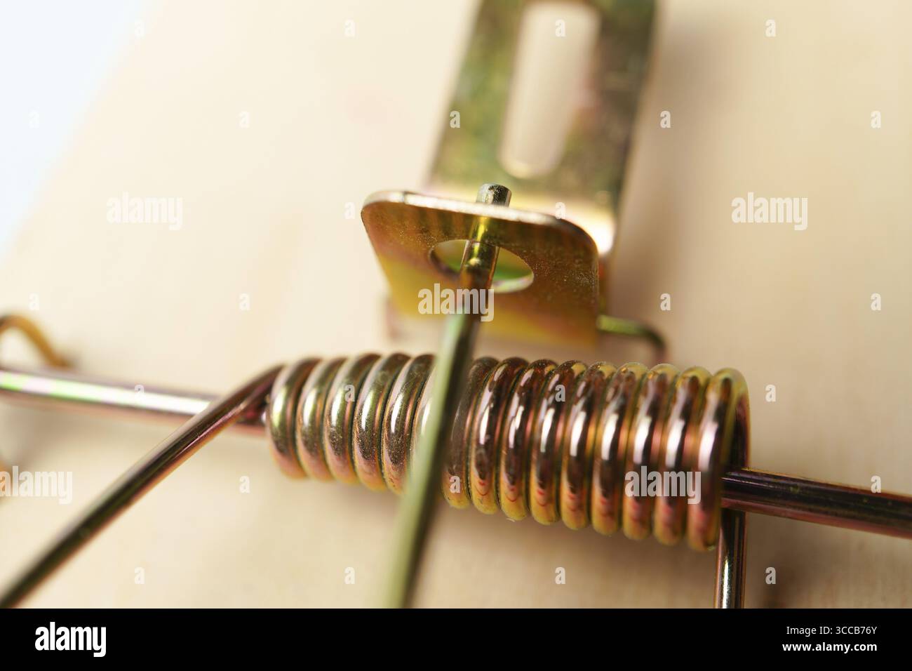 Close-up of a mousetrap, highlighting the metal spring and trigger ...