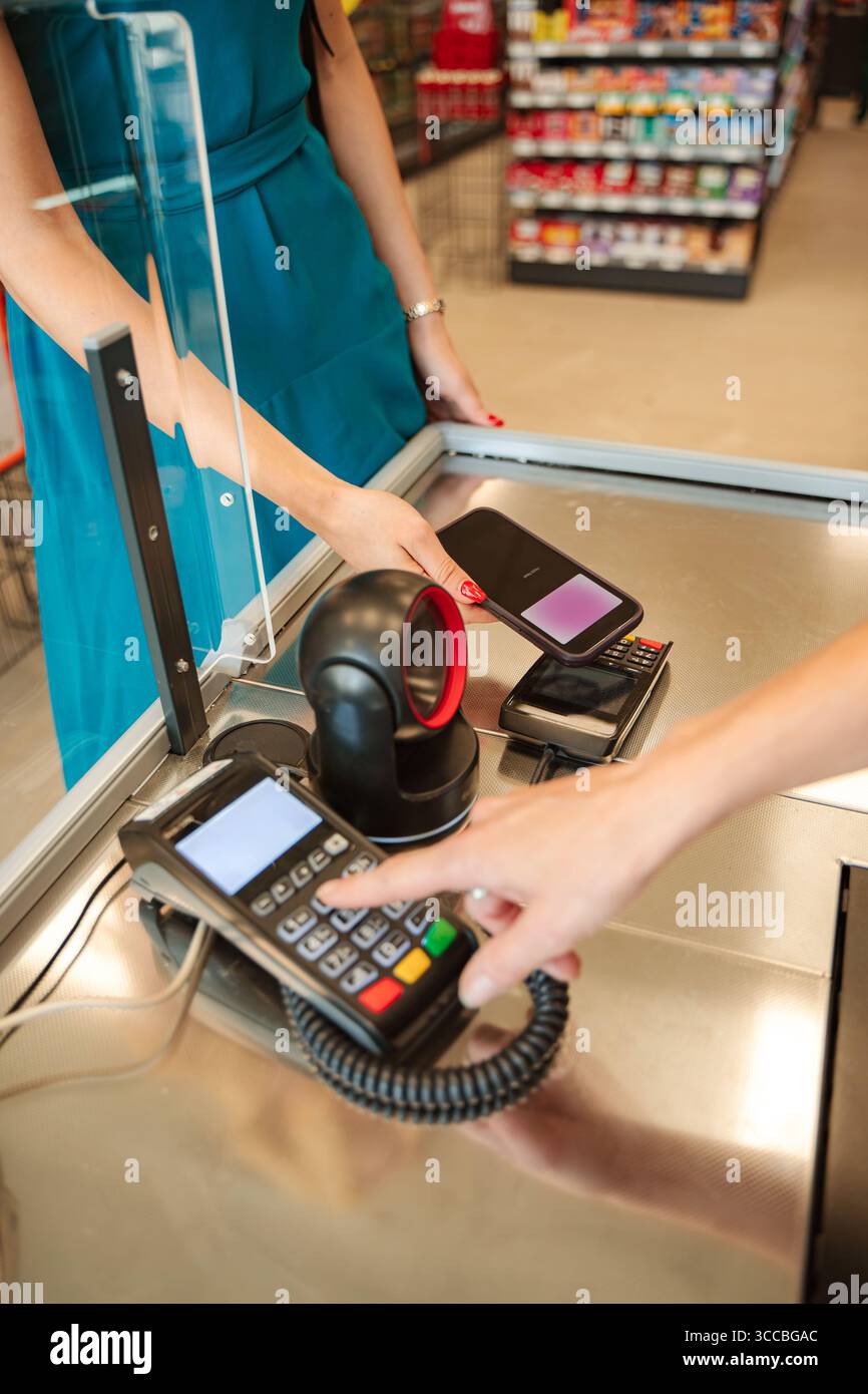 Customer paying with smartphone at supermarket checkout Stock Photo - Alamy