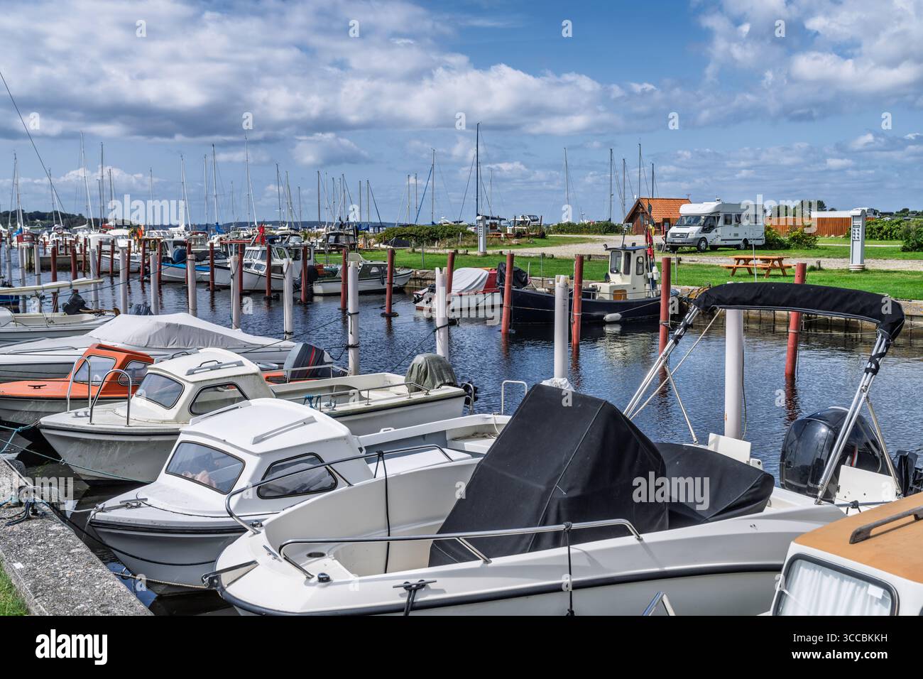 Peaceful marina featuring various docked boats under a partially cloudy ...
