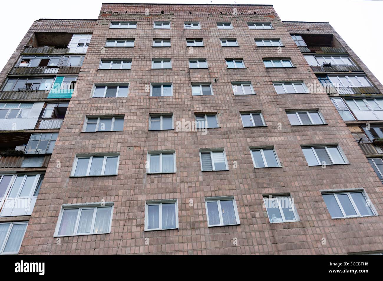 A tall, weathered building stands proudly among other structures ...
