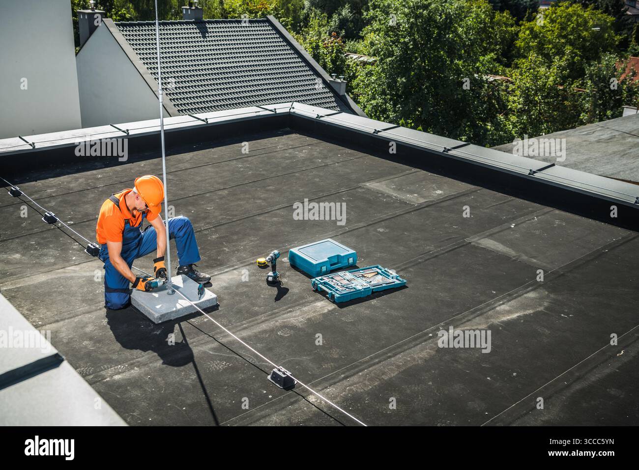 A technician wearing safety gear is installing lightning protection ...