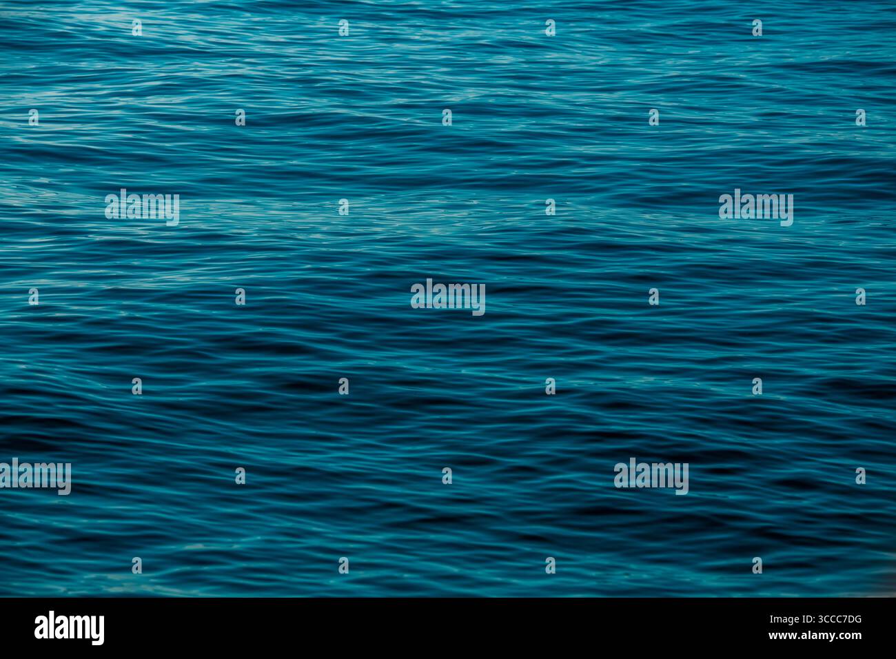 The tranquil surface of turquoise water displays gentle ripples under ...