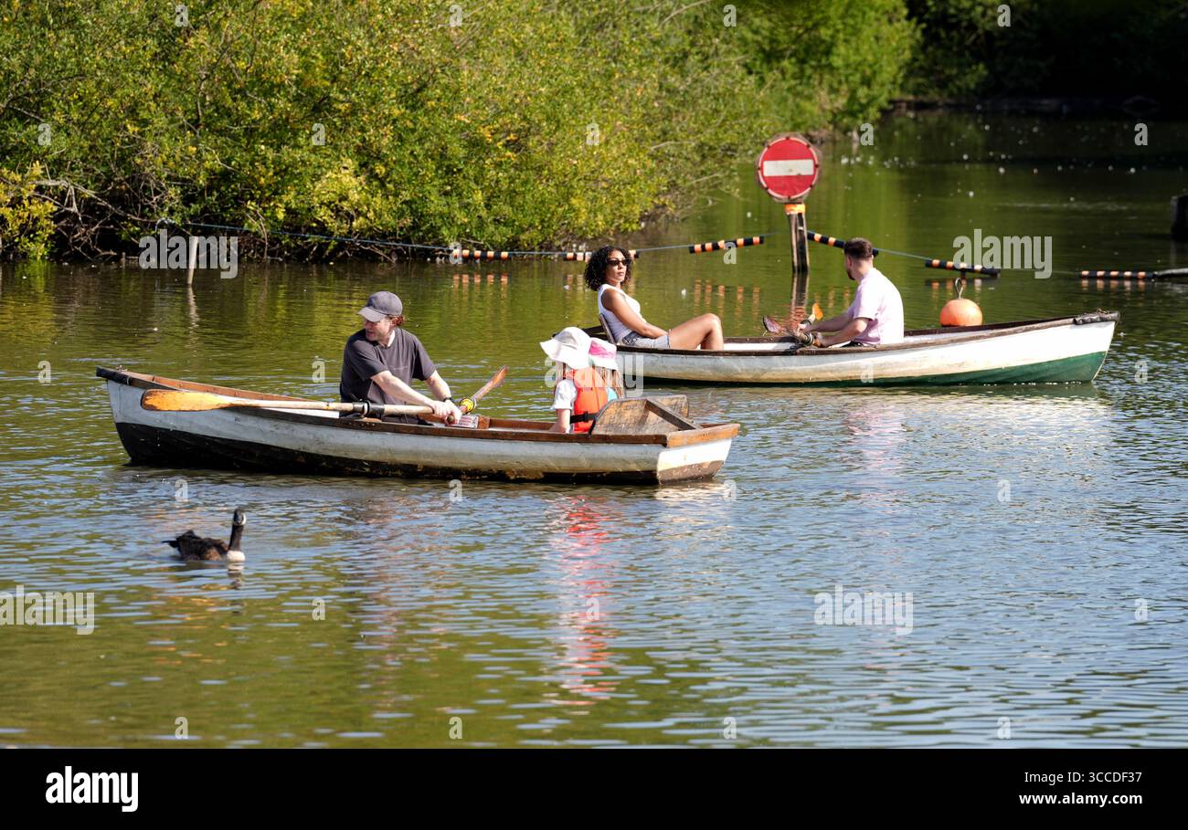 People in a rowing boat on Hollow Pond in east London, enjoy the hot ...