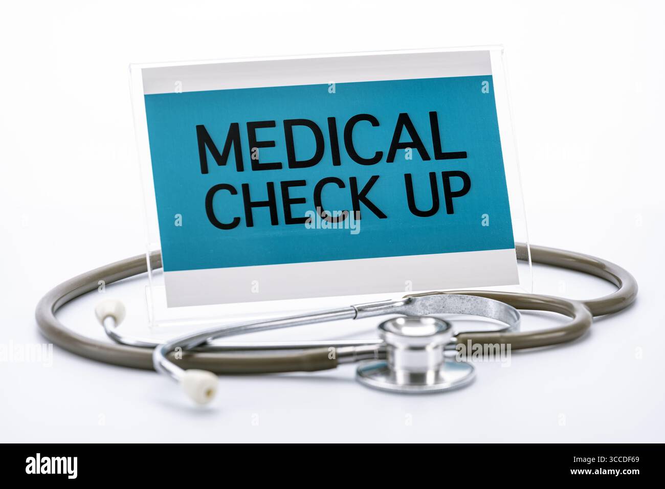 A stethoscope encircles sign reading medical check up on white ...
