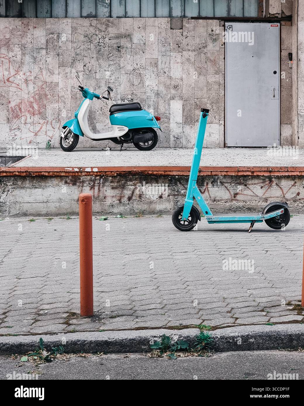 Technology difference: two blue scooters parked on the street. Side ...