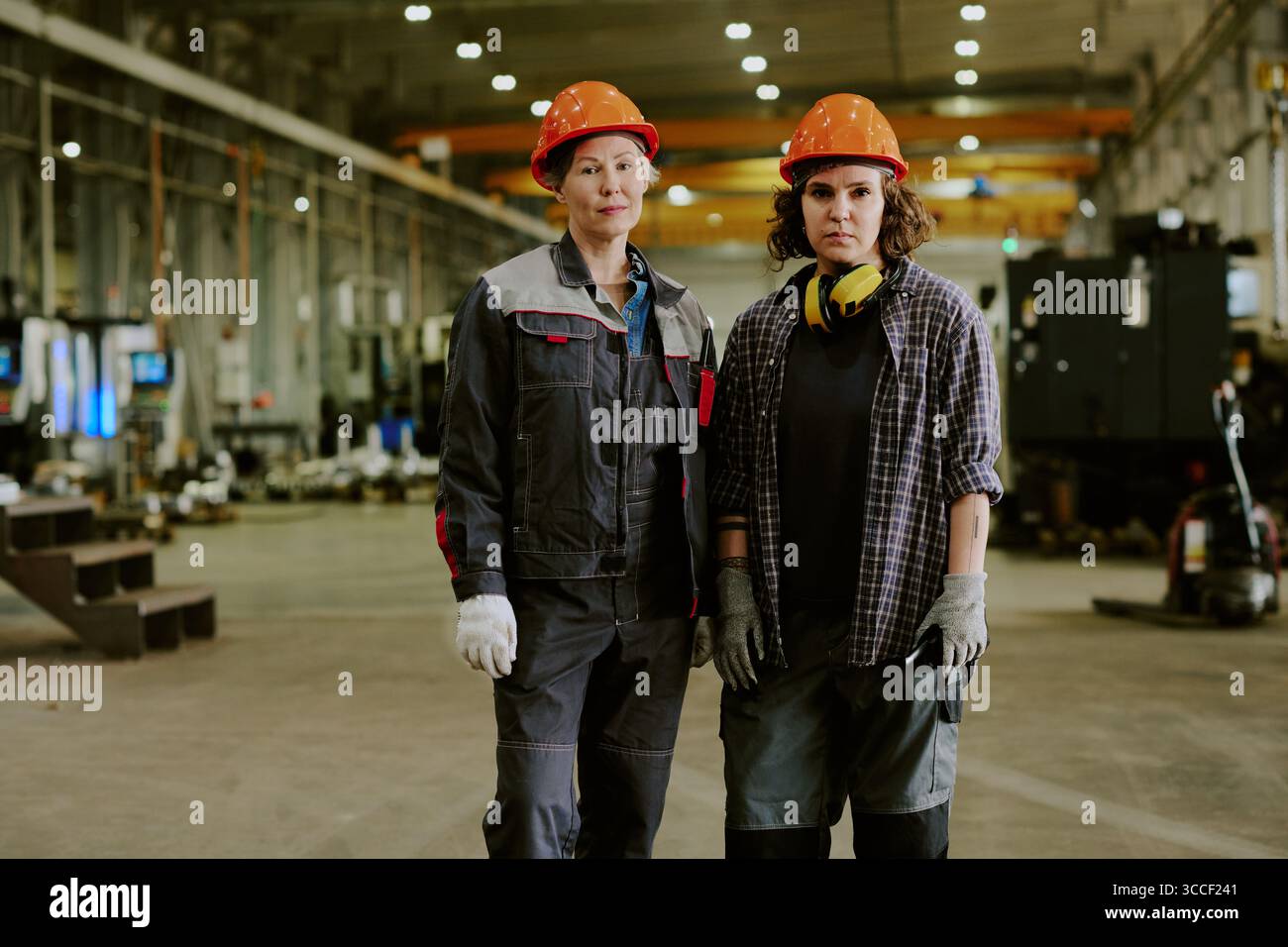 Portrait of Two Women Standing in Industrial Factory Stock Photo - Alamy