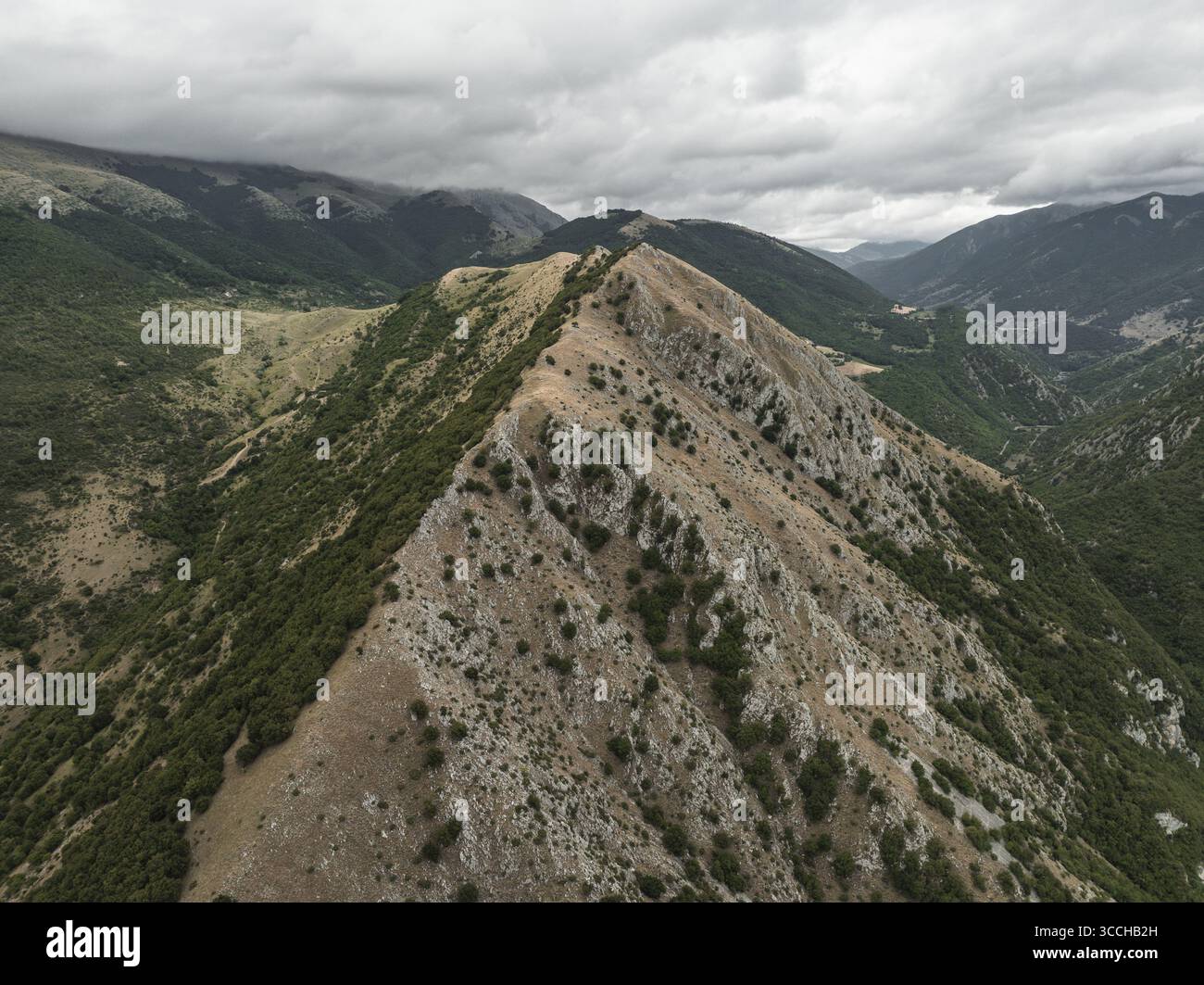 Aerial view of rugged mountain ridges and verdant valleys under a ...