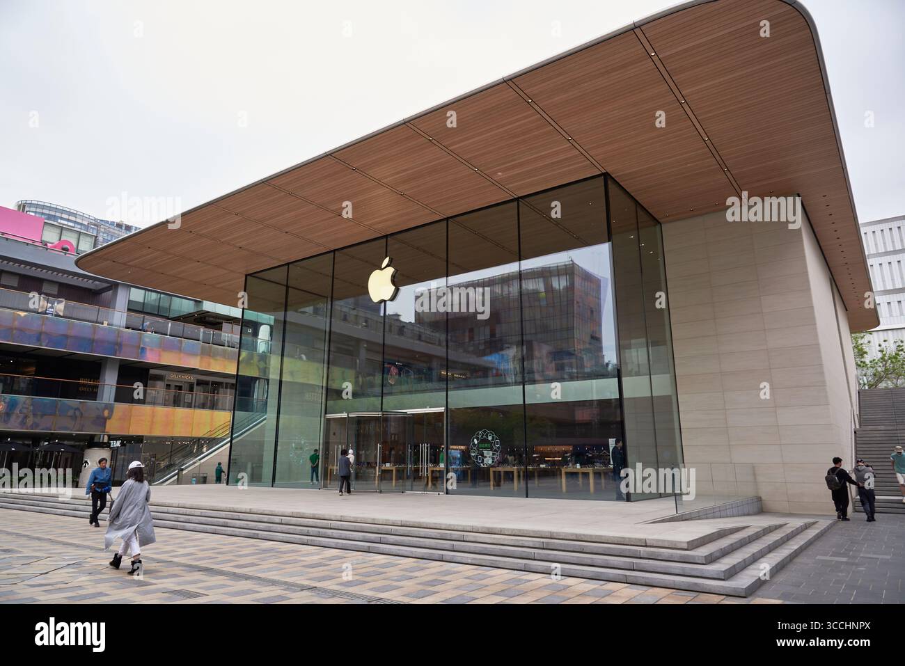 Modern Apple store with a large glass facade and wooden roof, located ...
